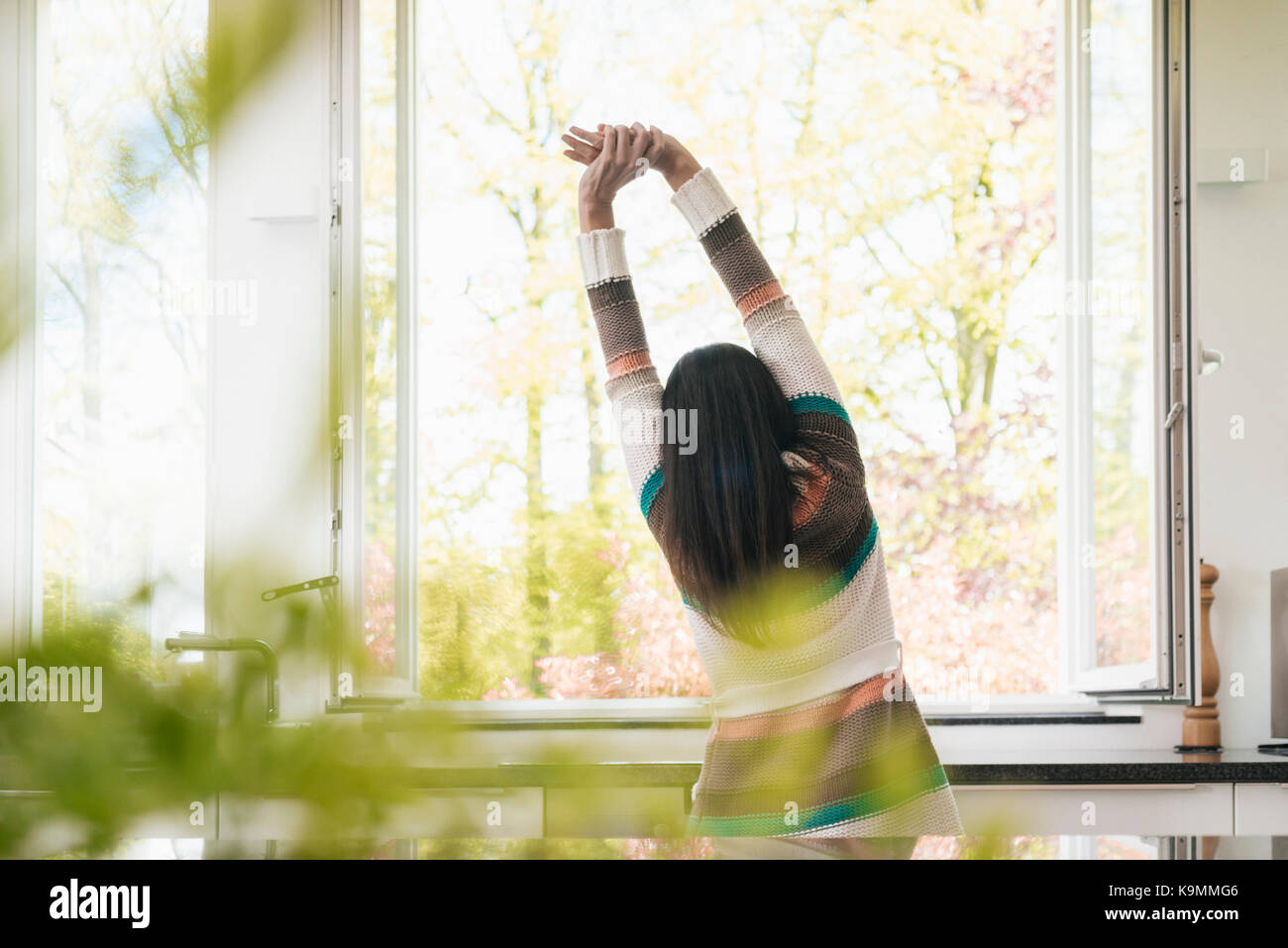 Woman stretching in kitchen Stock Photo - Alamy