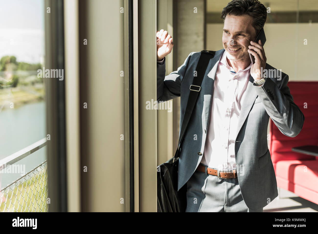 businessman standing by window, making a phone call Stock Photo - Alamy