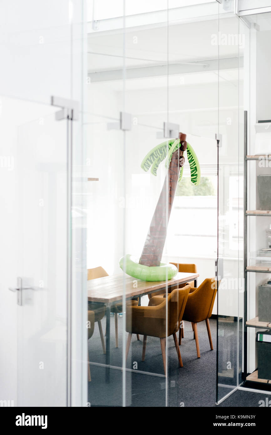 Inflatable palm tree on conference table in office Stock Photo - Alamy