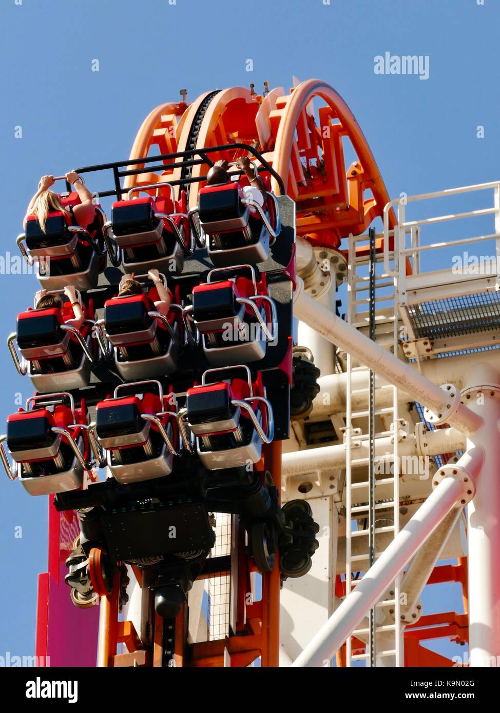 Close up of roller coaster riders climbing to loop over the top. Coney ...