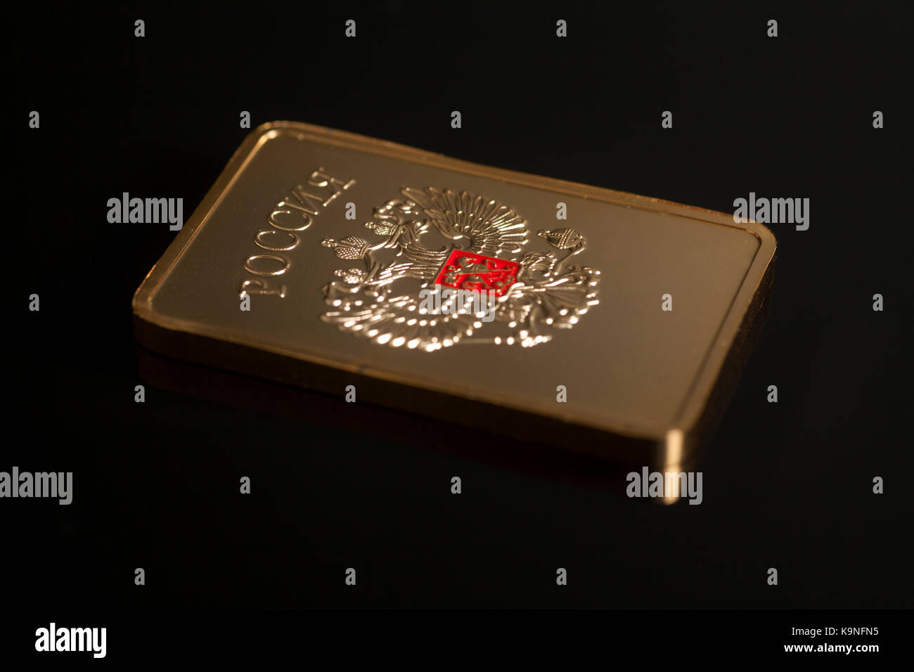 Gold bullion with emblem of Russia on black background Stock Photo - Alamy