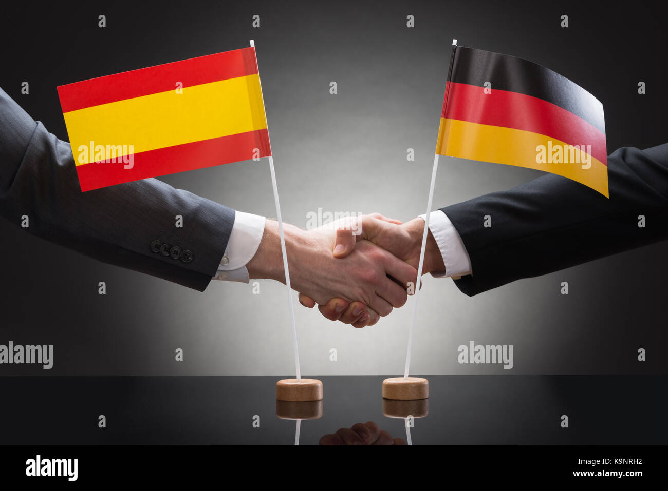 Close-up Of Two Businesspeople Shaking Hands In Front Of Spain And ...