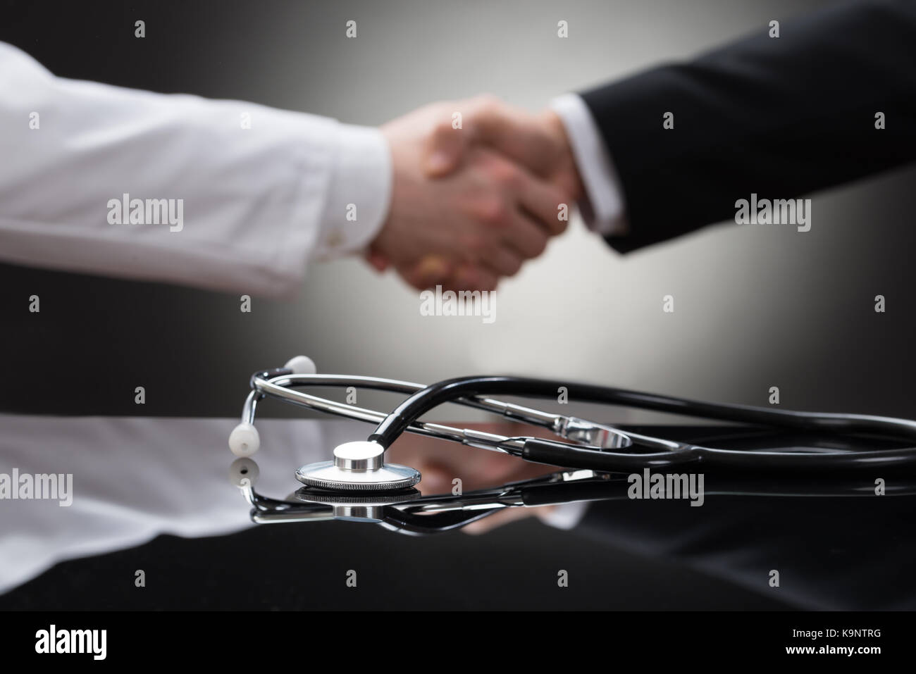 Doctor And Businessman Shaking Hand In Front Of Stethoscope Stock Photo ...