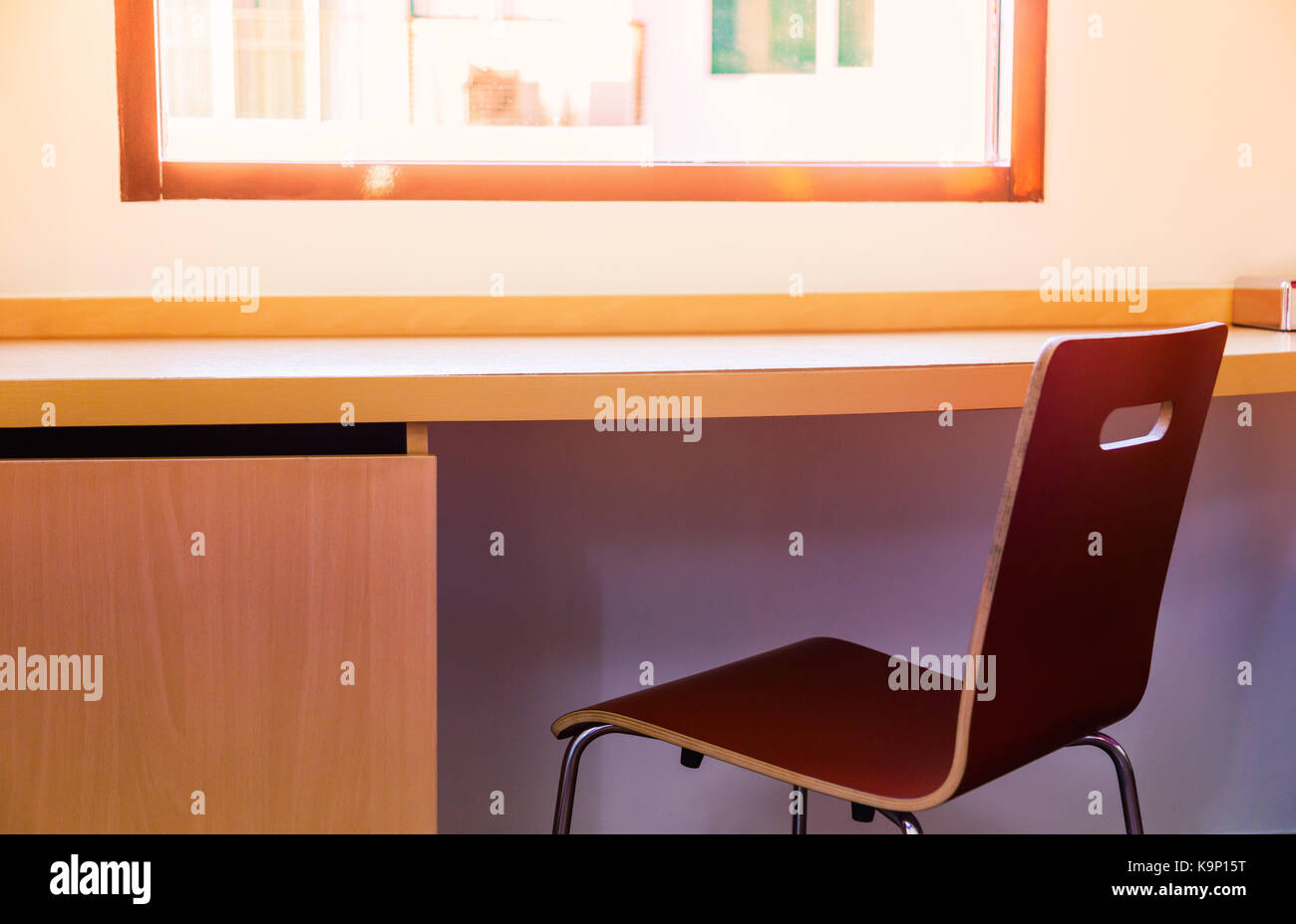 empty office working desk and chair by the bright window with bright ...