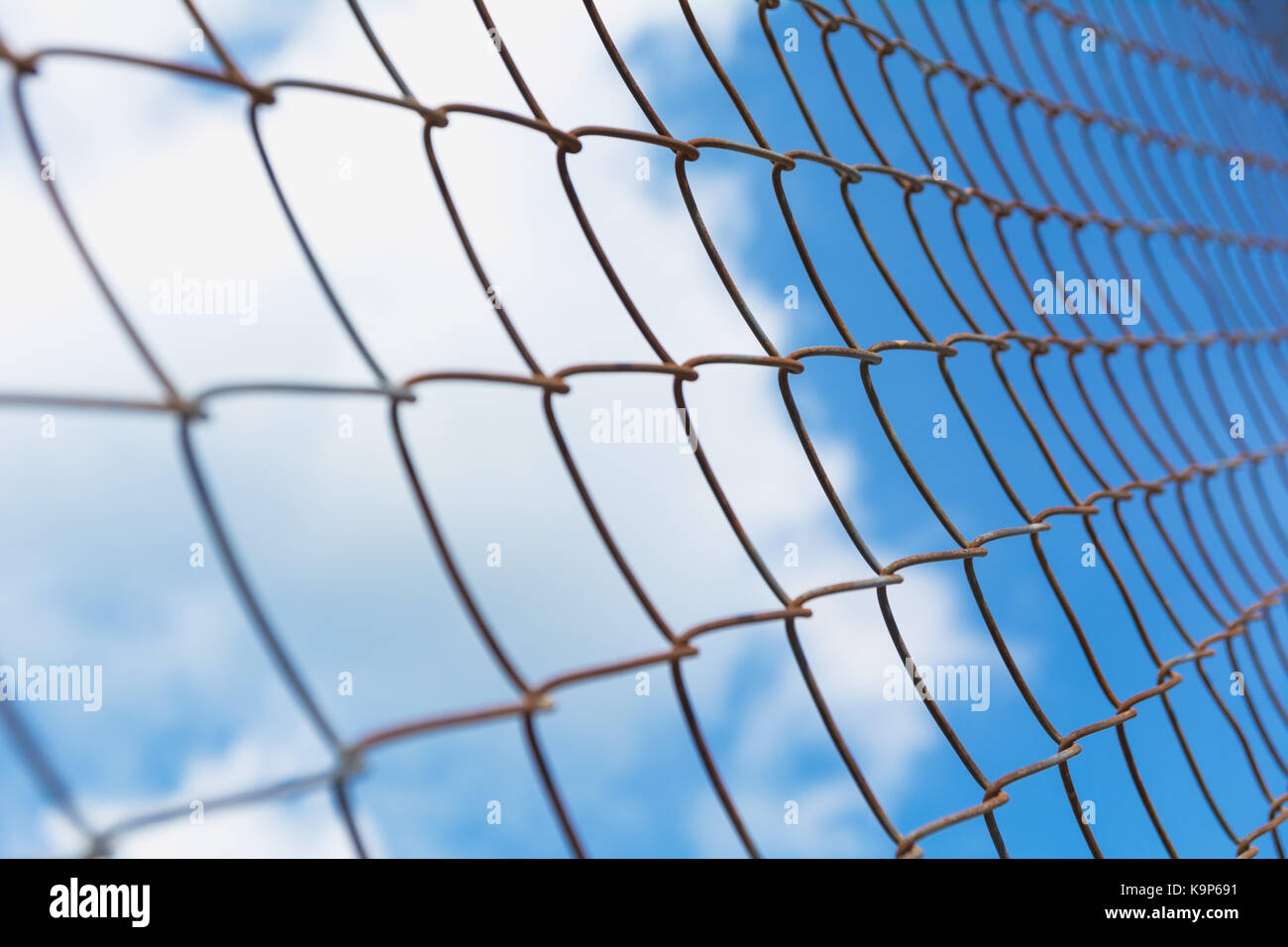 Rusty chain link fence under the sky background. Abstract closeup of a ...