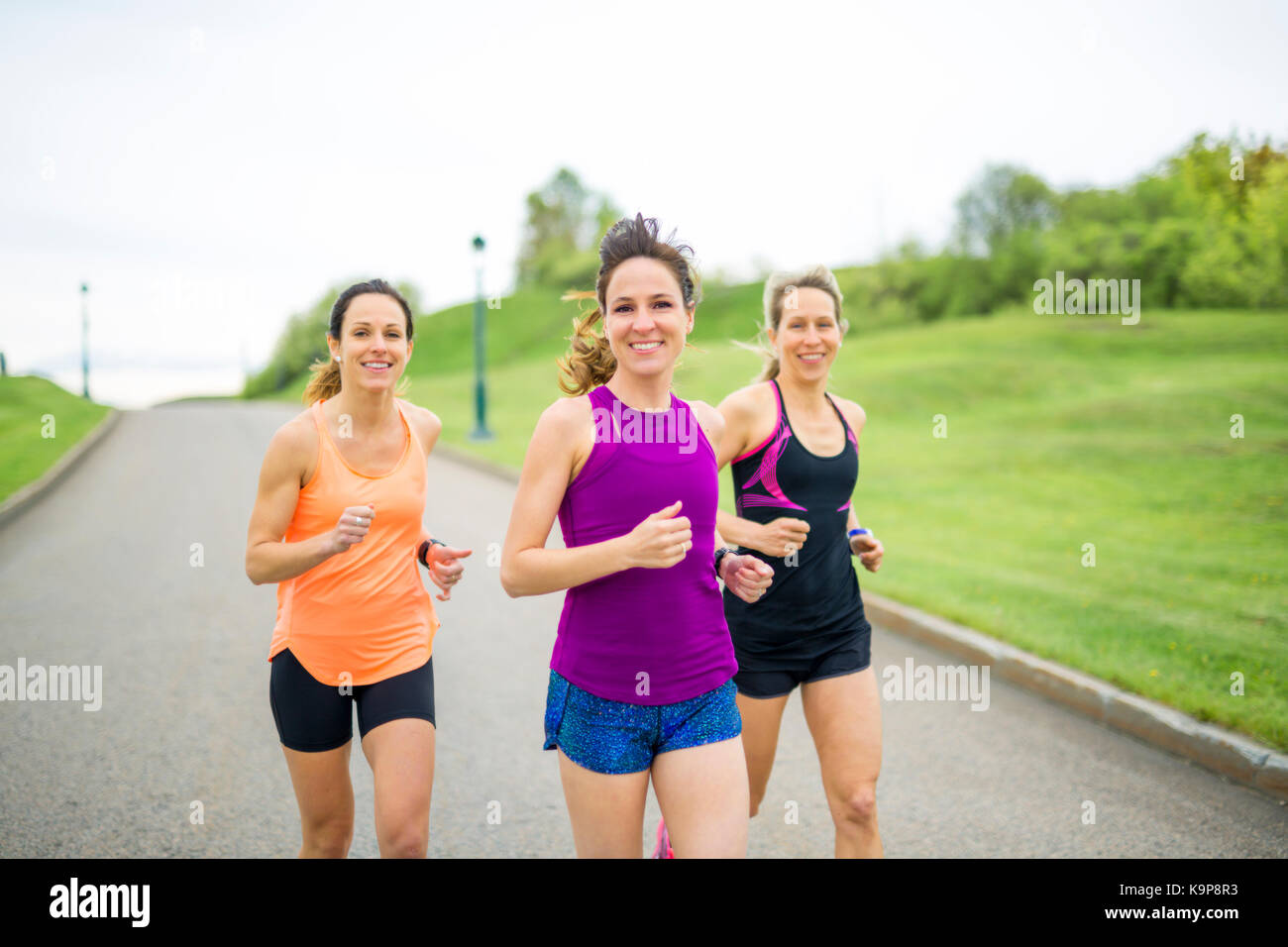 Three nice relaxed runners on a paved jogging daylight Stock Photo - Alamy