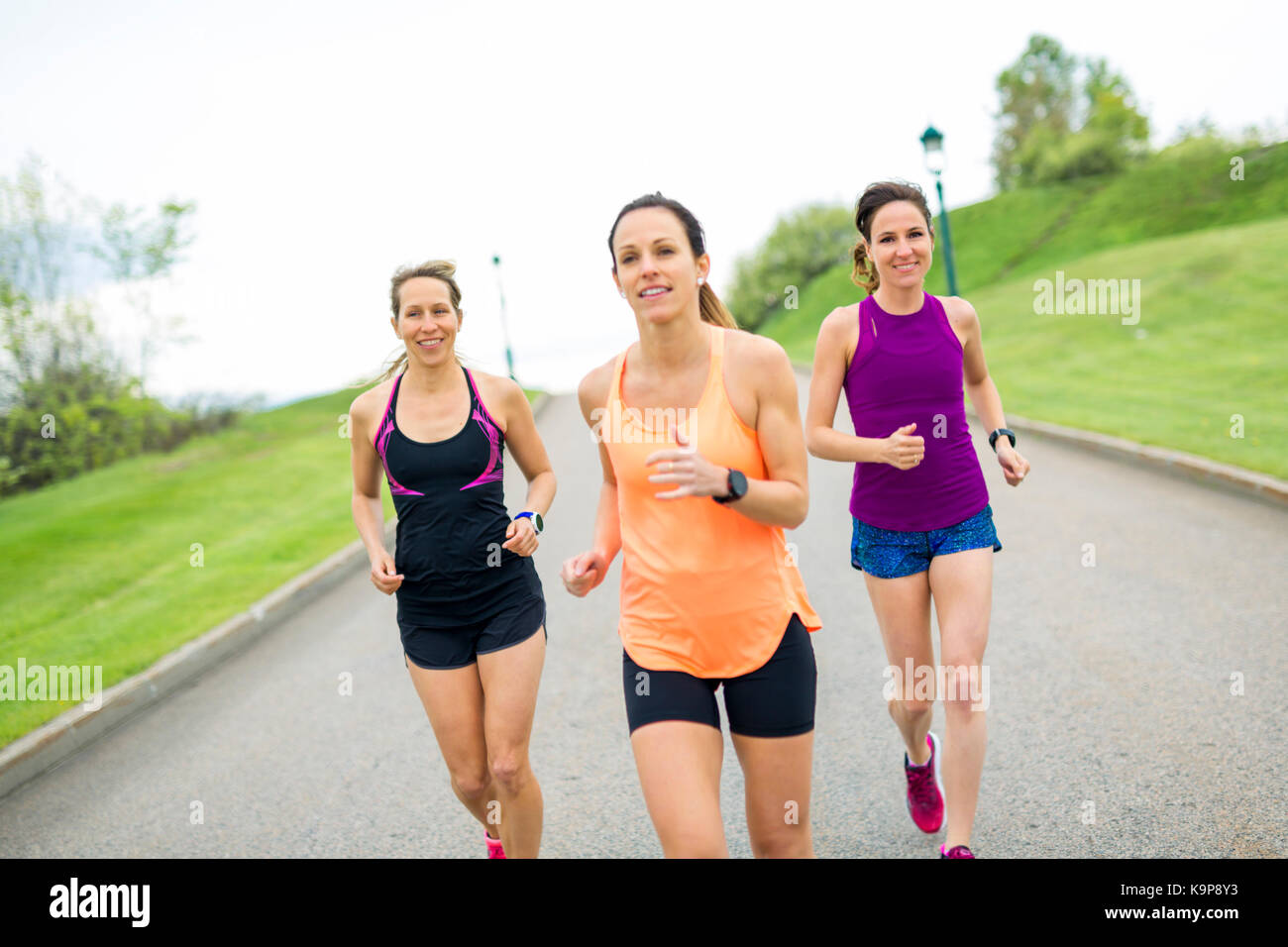 Three nice relaxed runners on a paved jogging daylight Stock Photo - Alamy