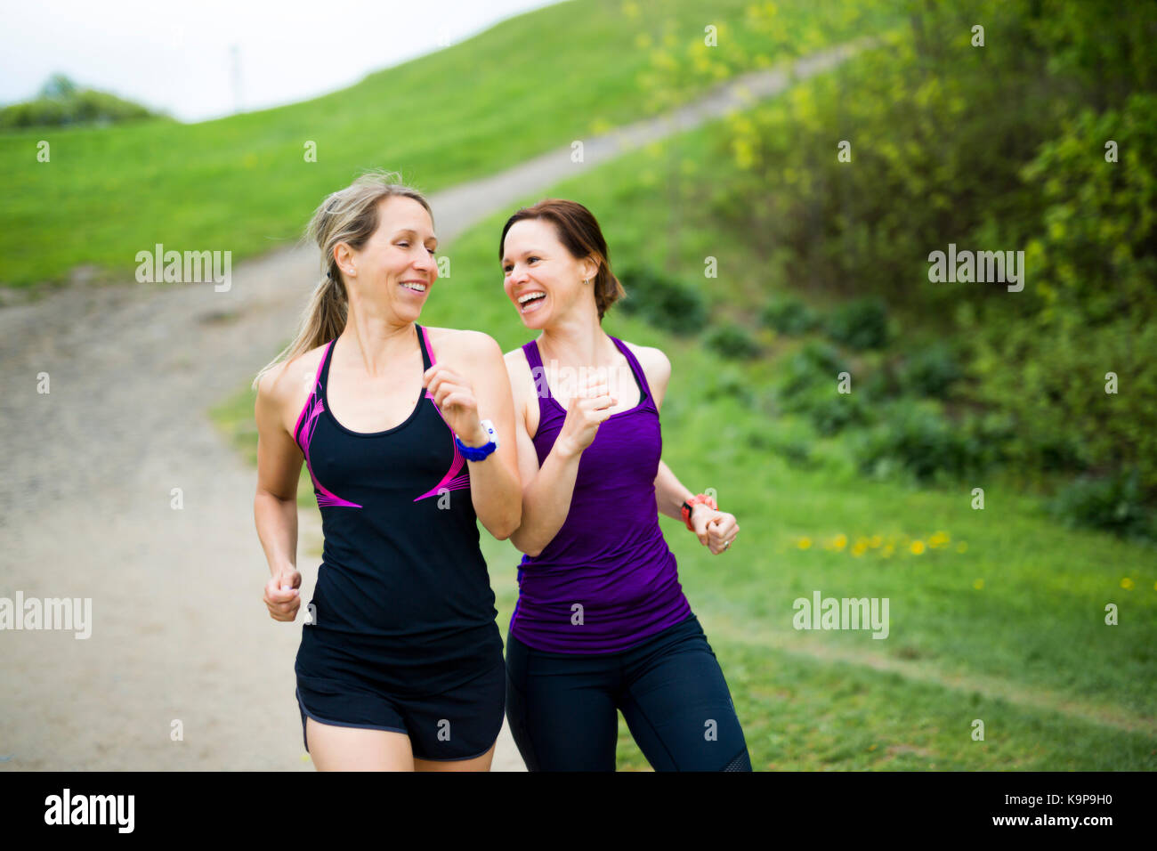 Two Beautiful Female runner outside having fun Stock Photo - Alamy