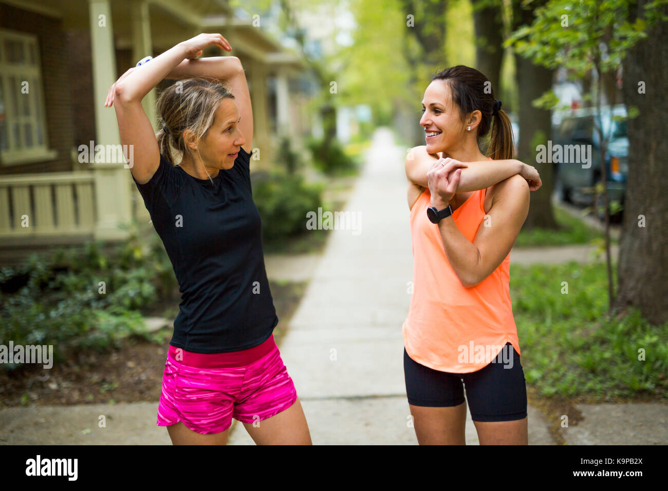 Two Beautiful Female runner outside having fun Stock Photo - Alamy