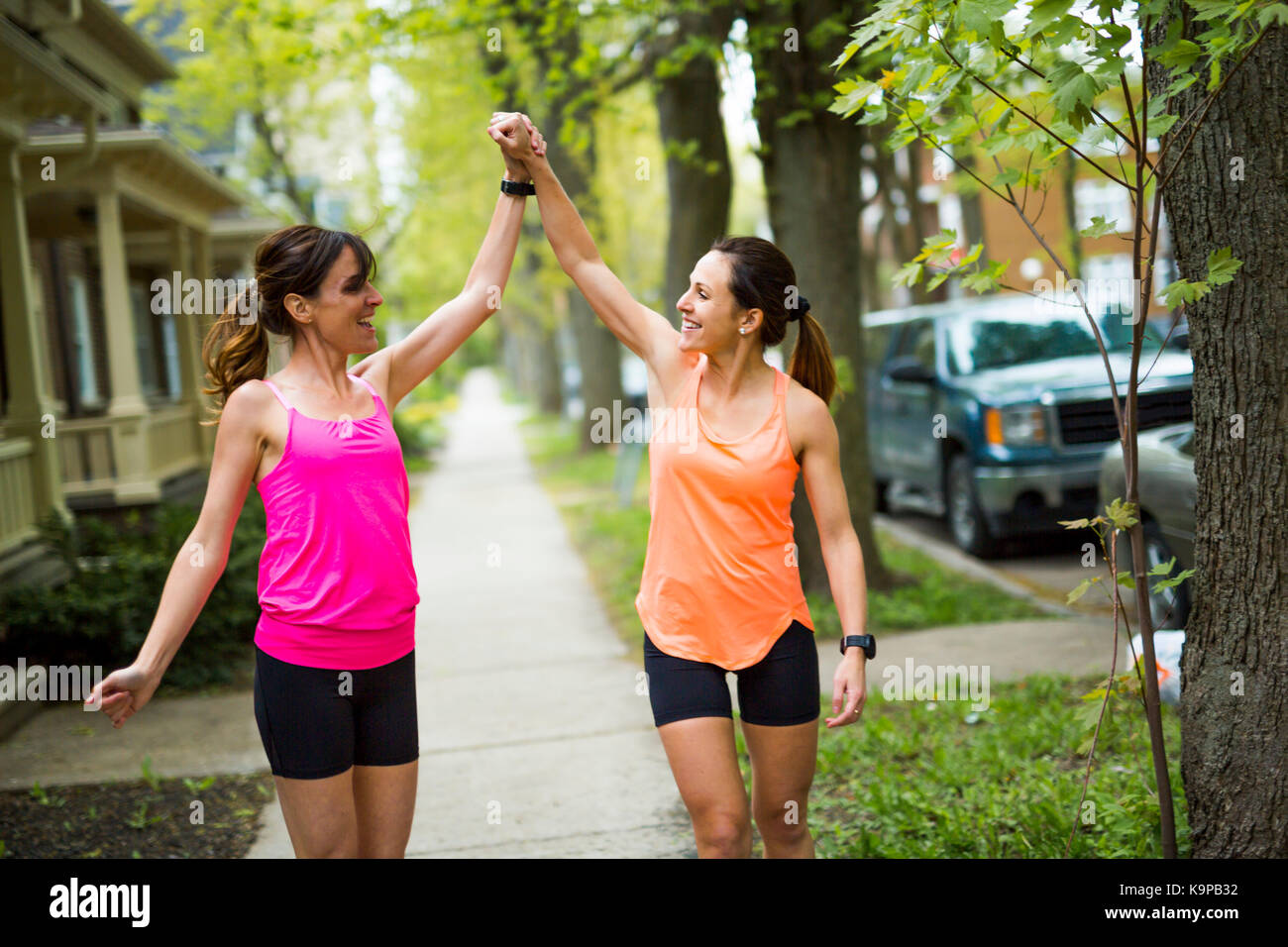 Two Beautiful Female runner outside having fun Stock Photo - Alamy