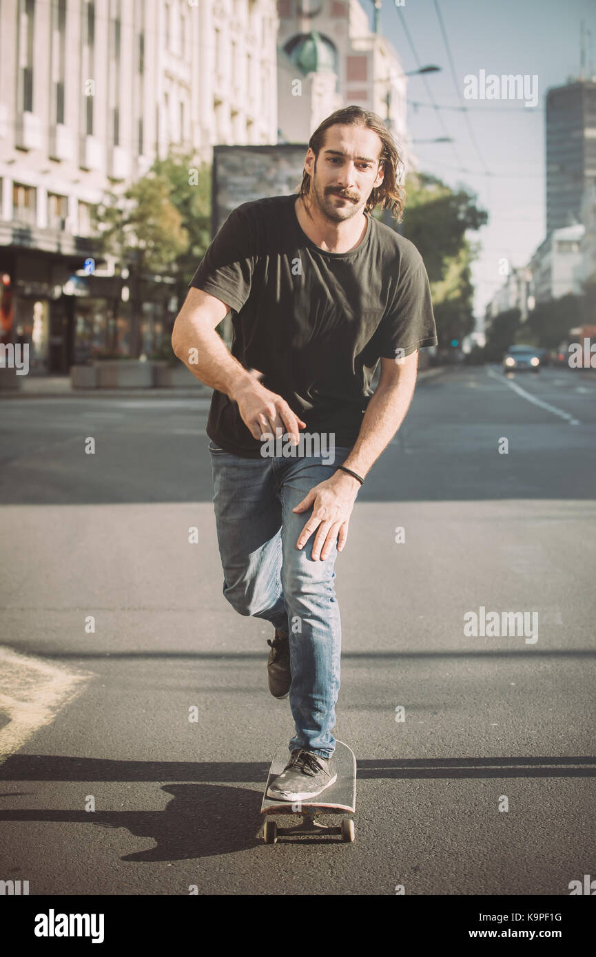 Professional skater riding skate on the main streets through cars and ...