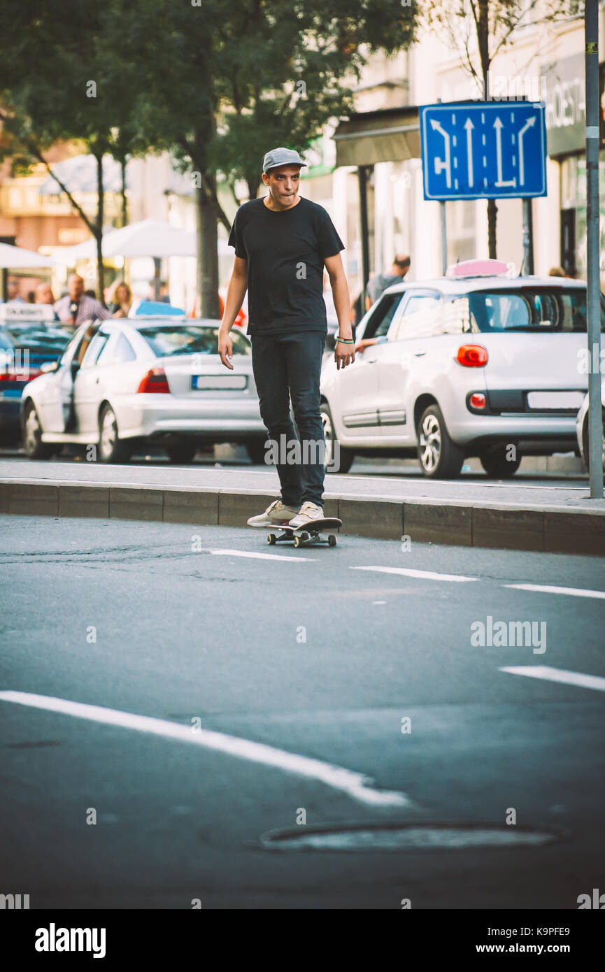 Professional skater riding skate on the main streets through cars and ...