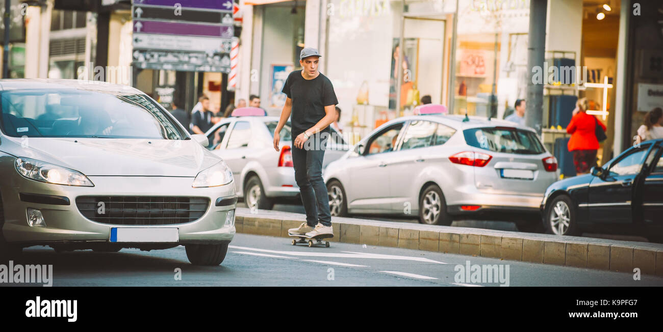 Professional skater riding skate on the main streets through cars and ...