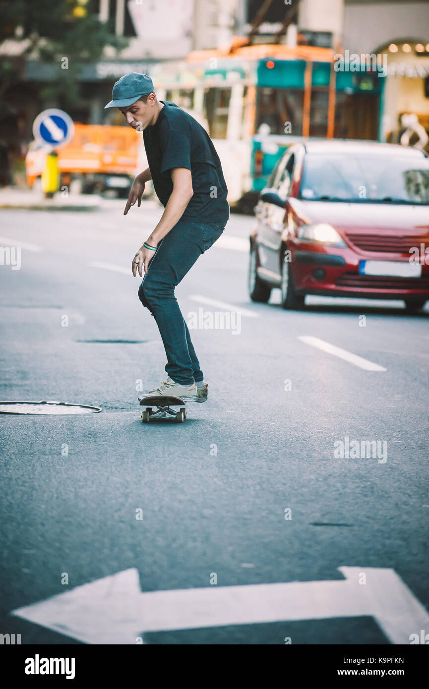 Professional skater riding skate on the main streets through cars and ...