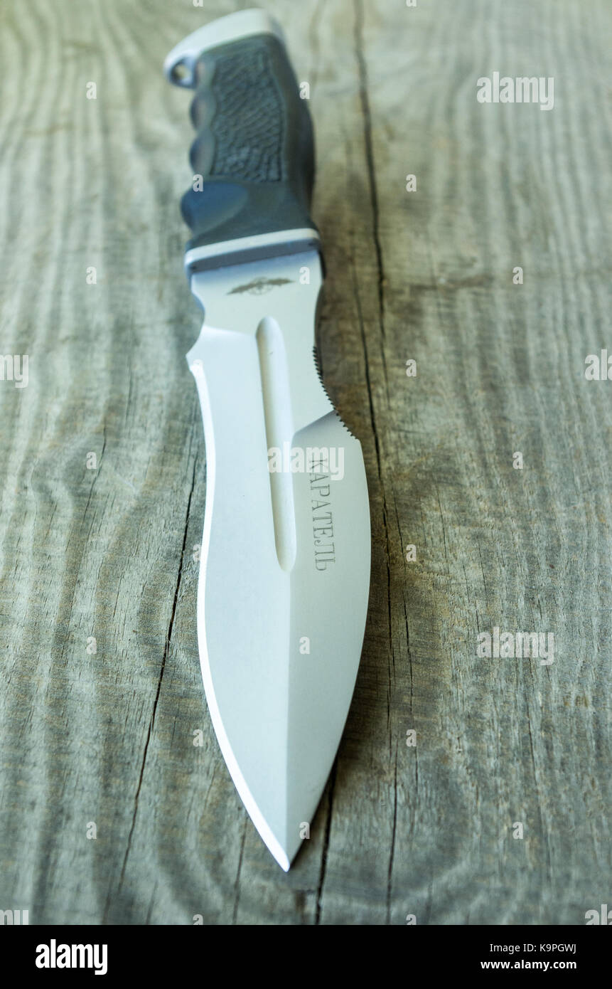 A big army knife. Vertical shot. Wooden background Stock Photo - Alamy