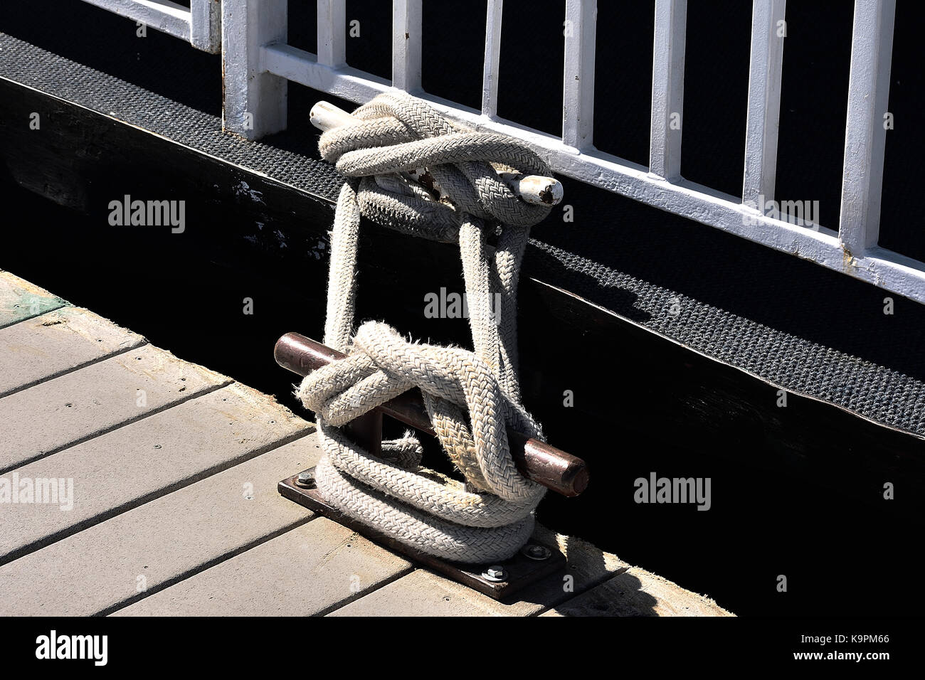 Rope knotted to a bollard at a wooden pier or wharf Stock Photo - Alamy