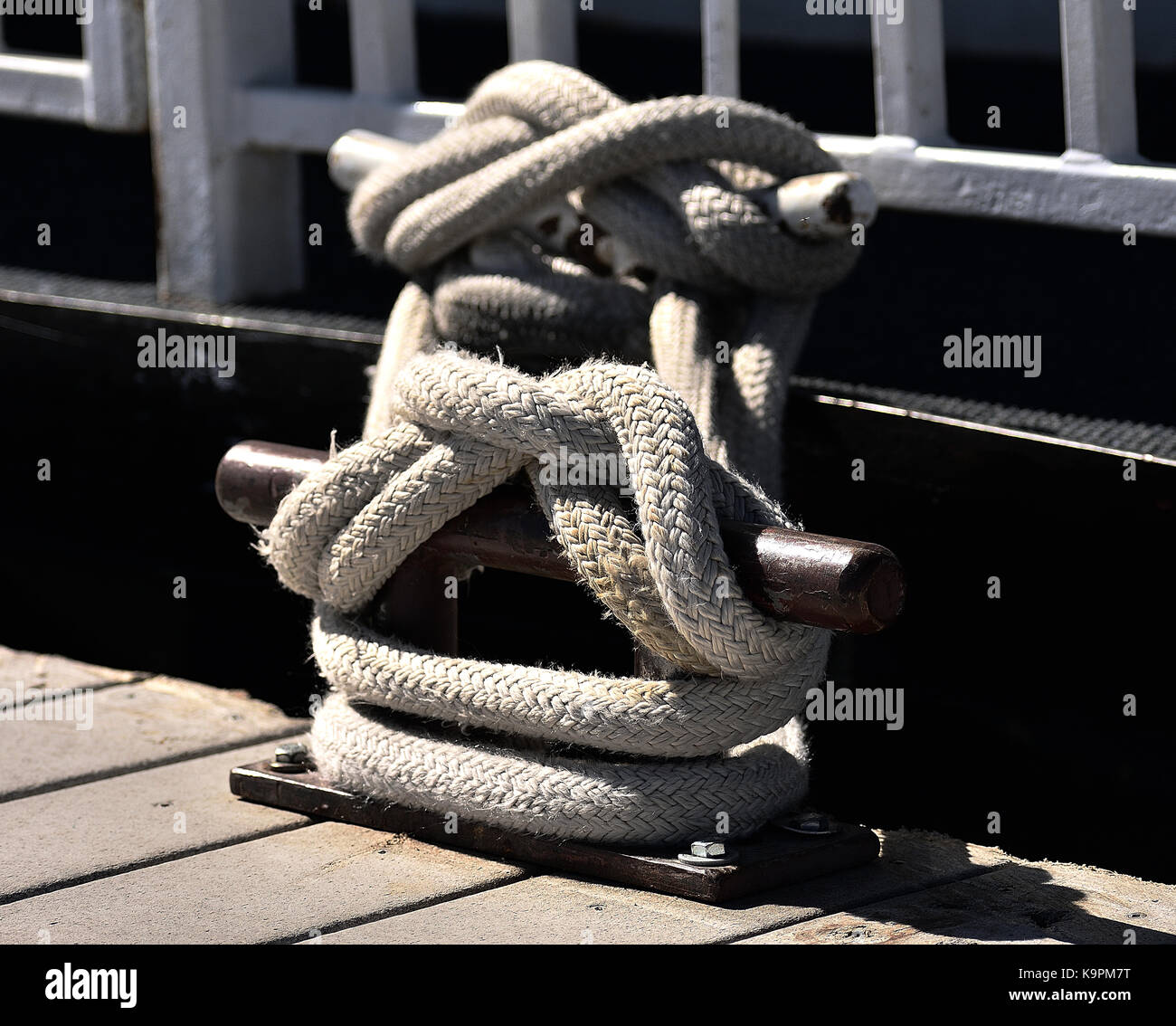 Rope knotted to a bollard at a wooden pier or wharf Stock Photo - Alamy