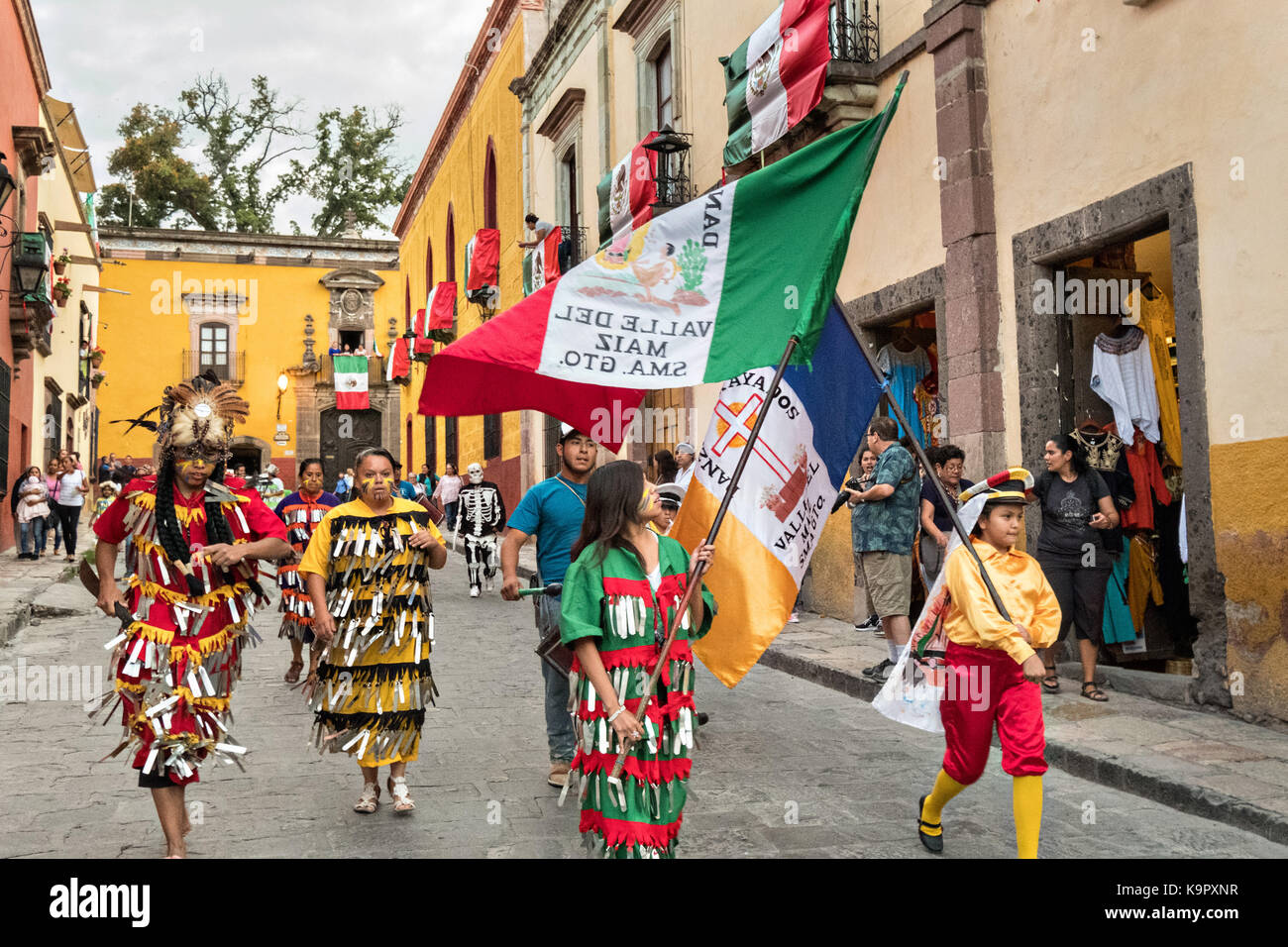 Costumed Aztec indians follow a statue of Saint Michael in a religious ...
