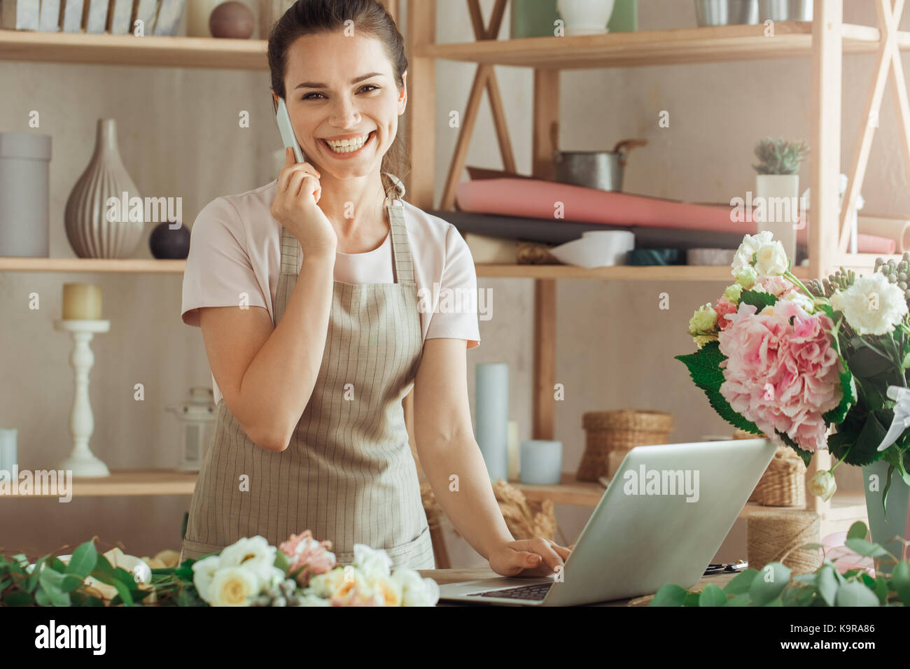 Young female florist working with flowers phone call Stock Photo - Alamy