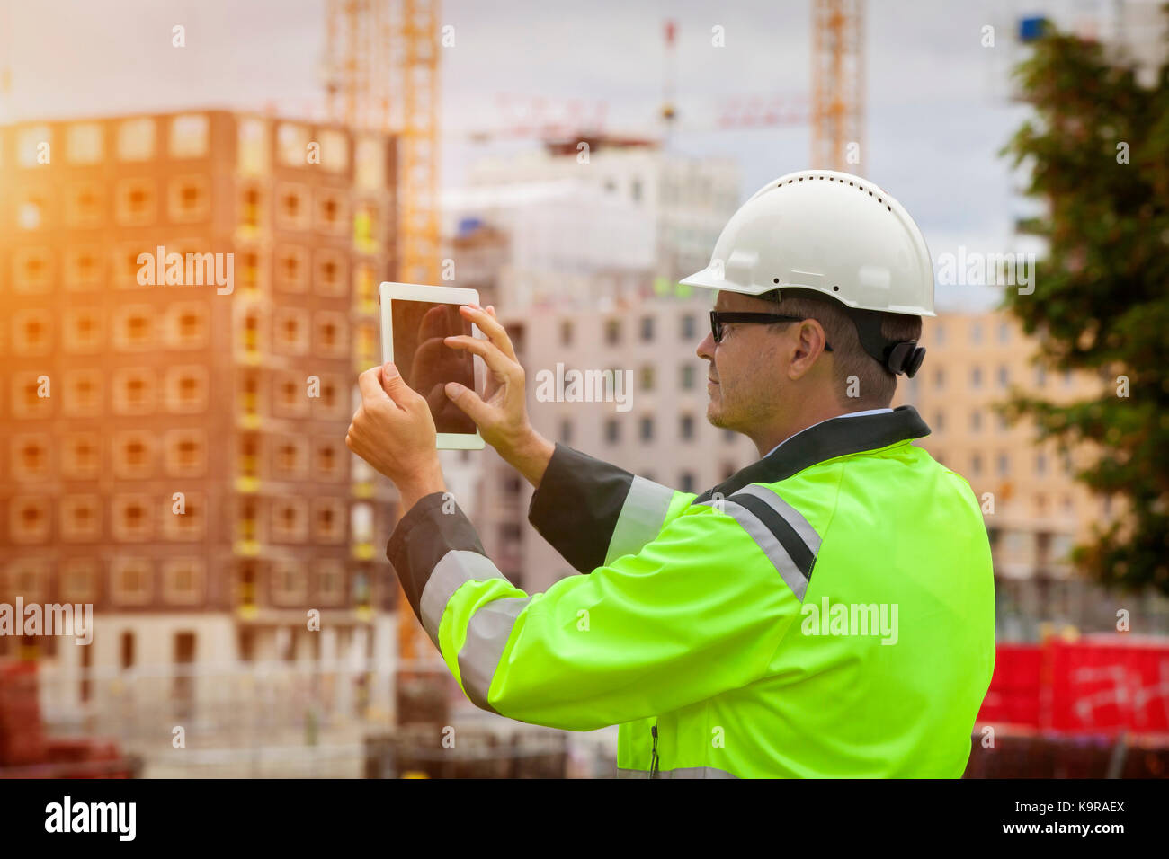 Construction engineer wearing safety vest with buildning in the ...