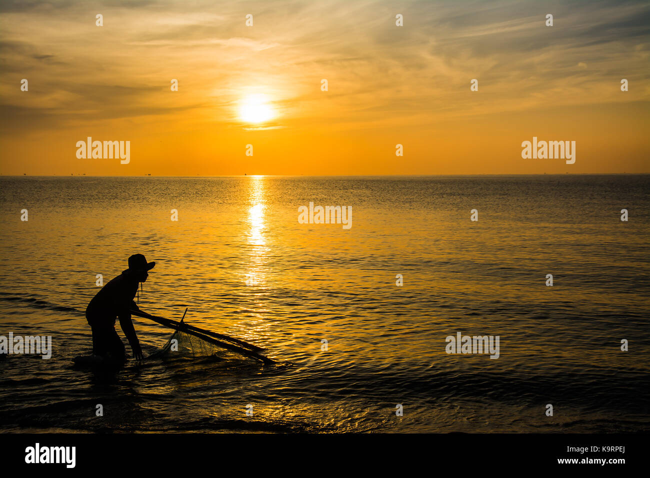traditional fishermen throwing net fishing in at sunrise time Stock ...