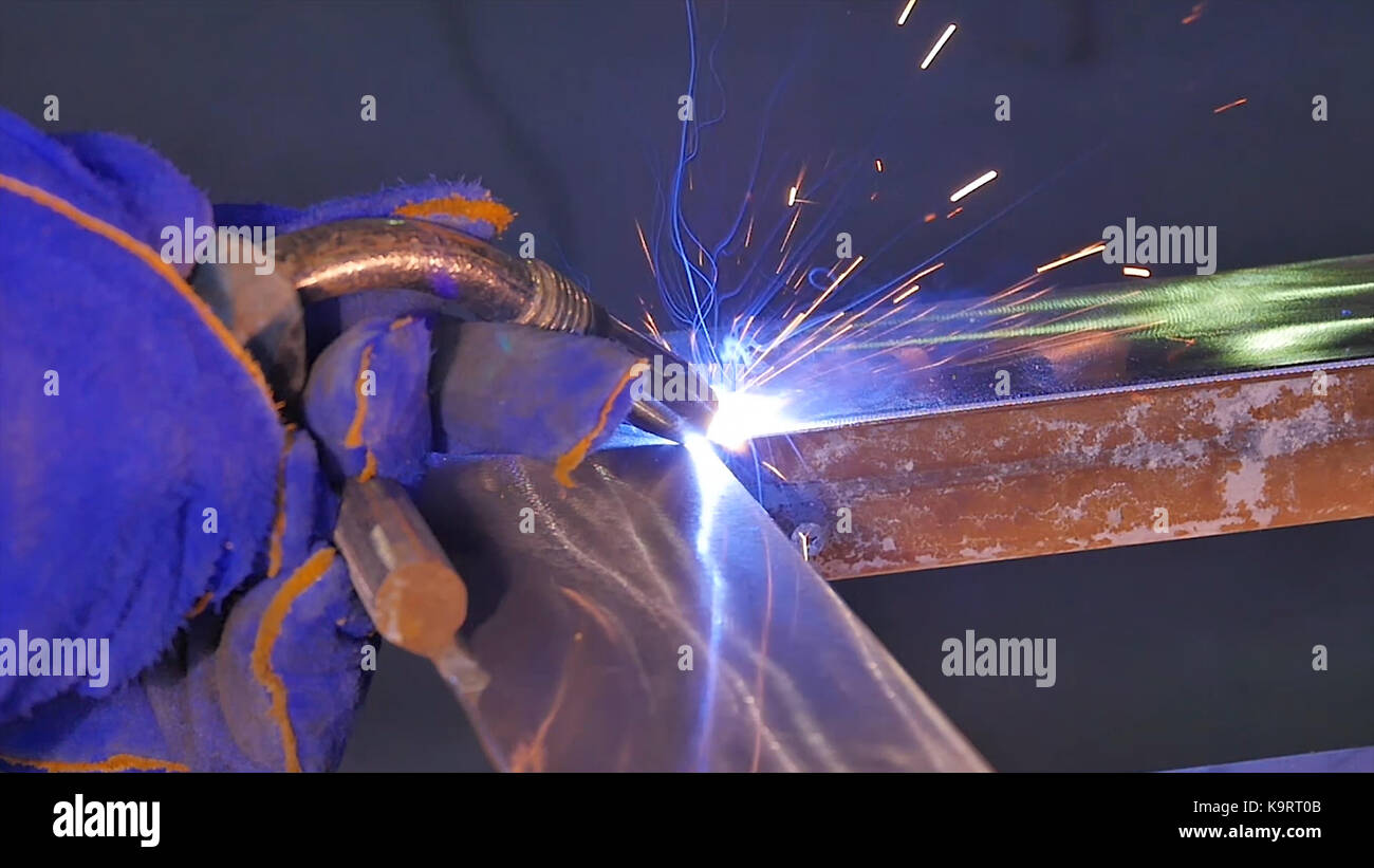 Metal Welding with sparks and smoke. Worker with protective mask ...