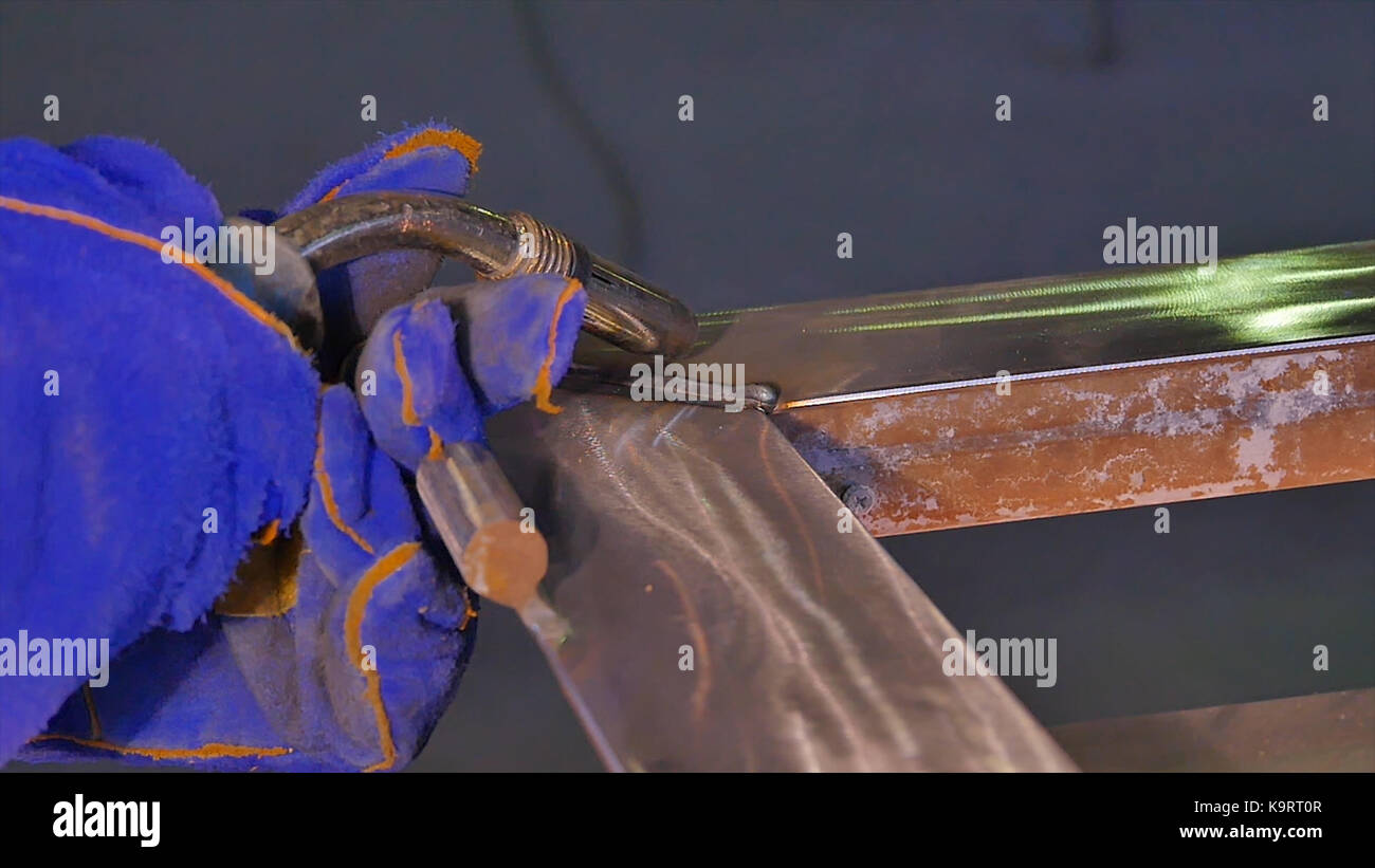 Metal Welding with sparks and smoke. Worker with protective mask ...