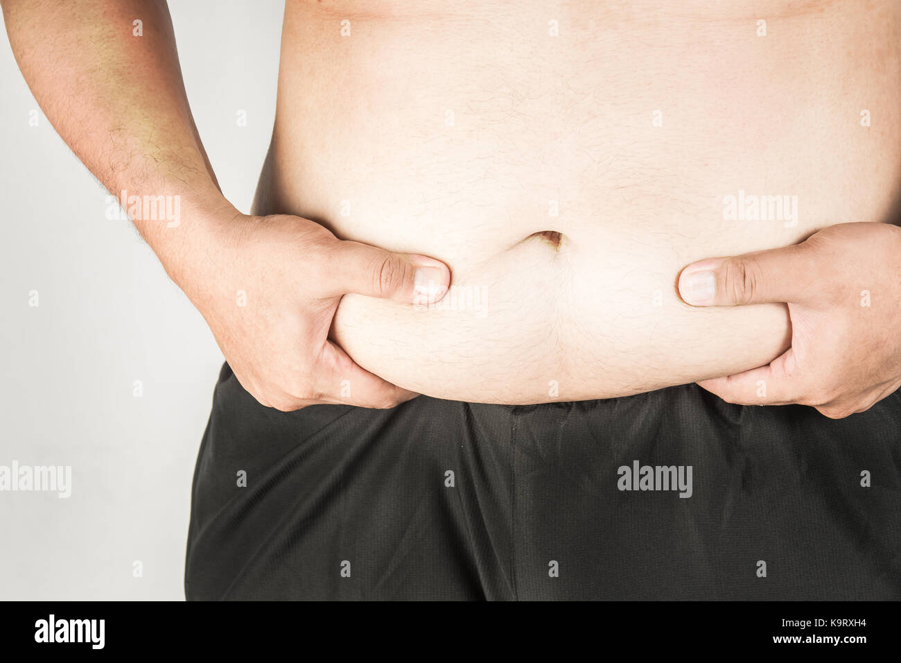 Overweight man body with hands touching belly fat Stock Photo - Alamy