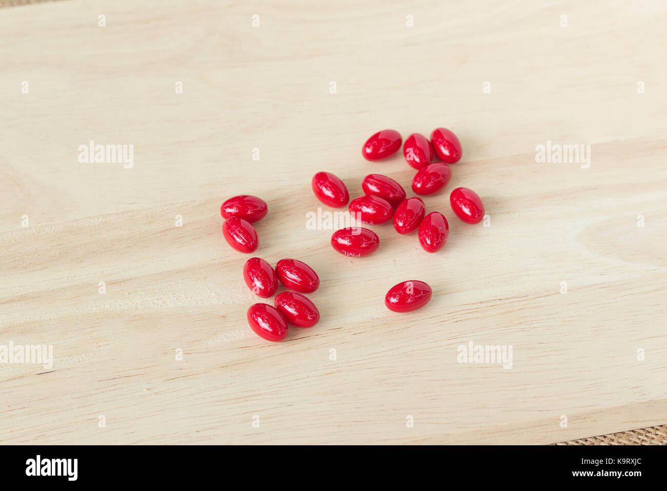 Image of red pills on wood background Stock Photo - Alamy