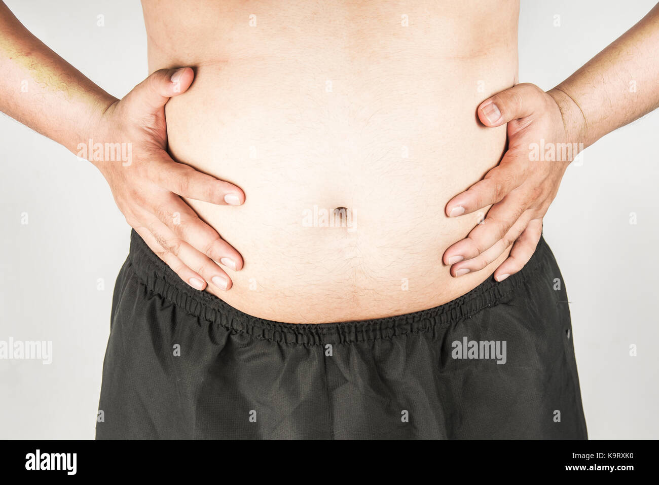 Overweight man body with hands touching belly fat Stock Photo - Alamy