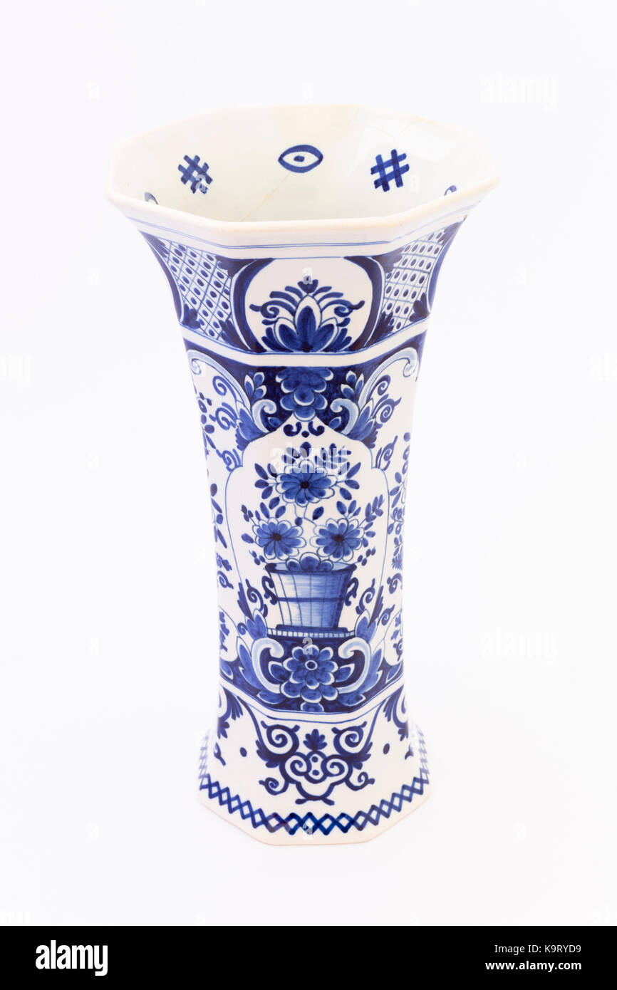 A tall ancient white ceramic flower vase painted with dark blue ...