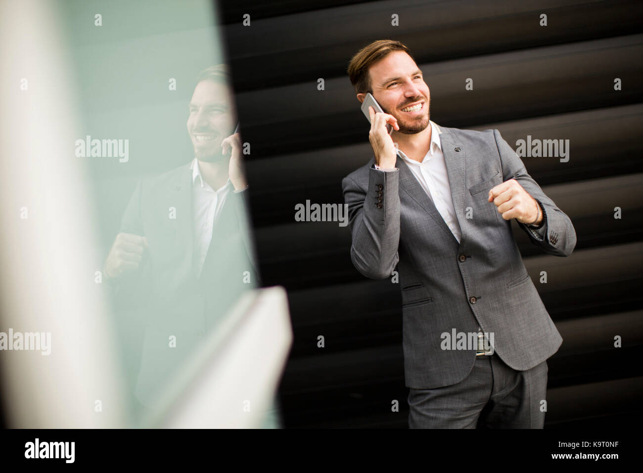 Young successful man executive businessman using his mobile cell phone ...