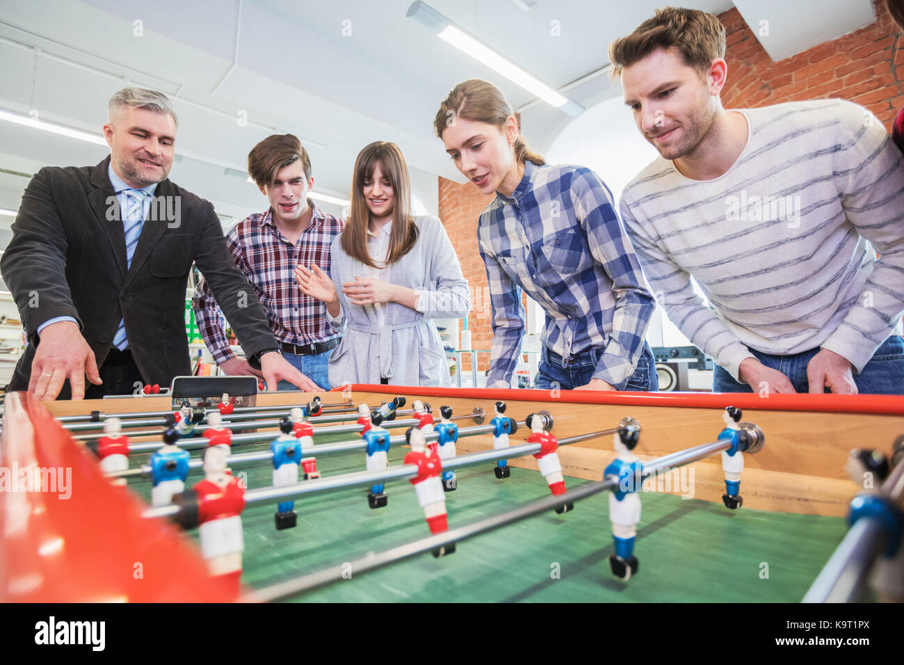 Happy friends playing table football hi-res stock photography and ...