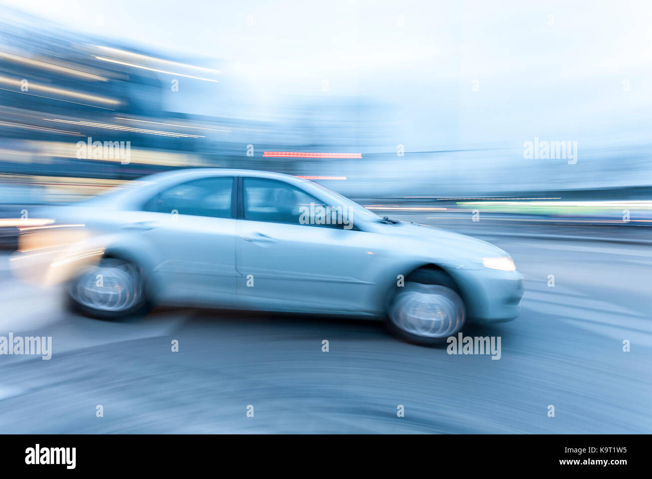 Blue car driving fast on country road Stock Photo - Alamy