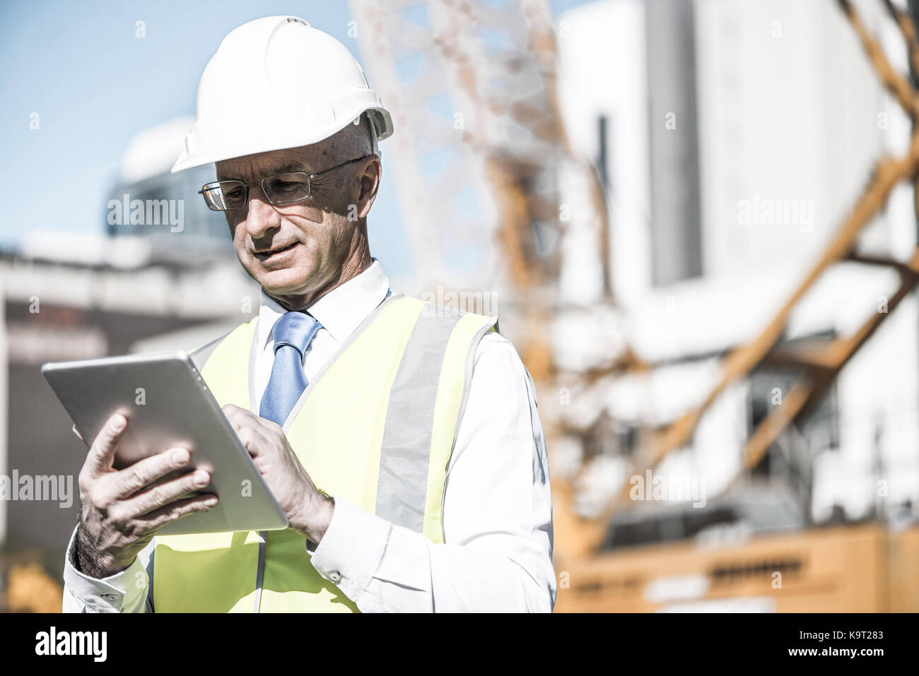 Construction manager controlling building site and tablet device Stock ...