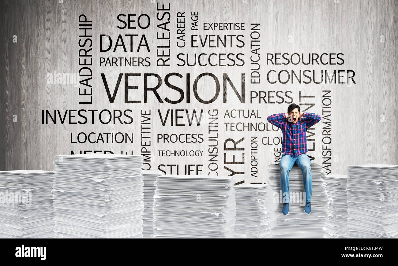Attractive man sitting on pile of paper documents Stock Photo - Alamy