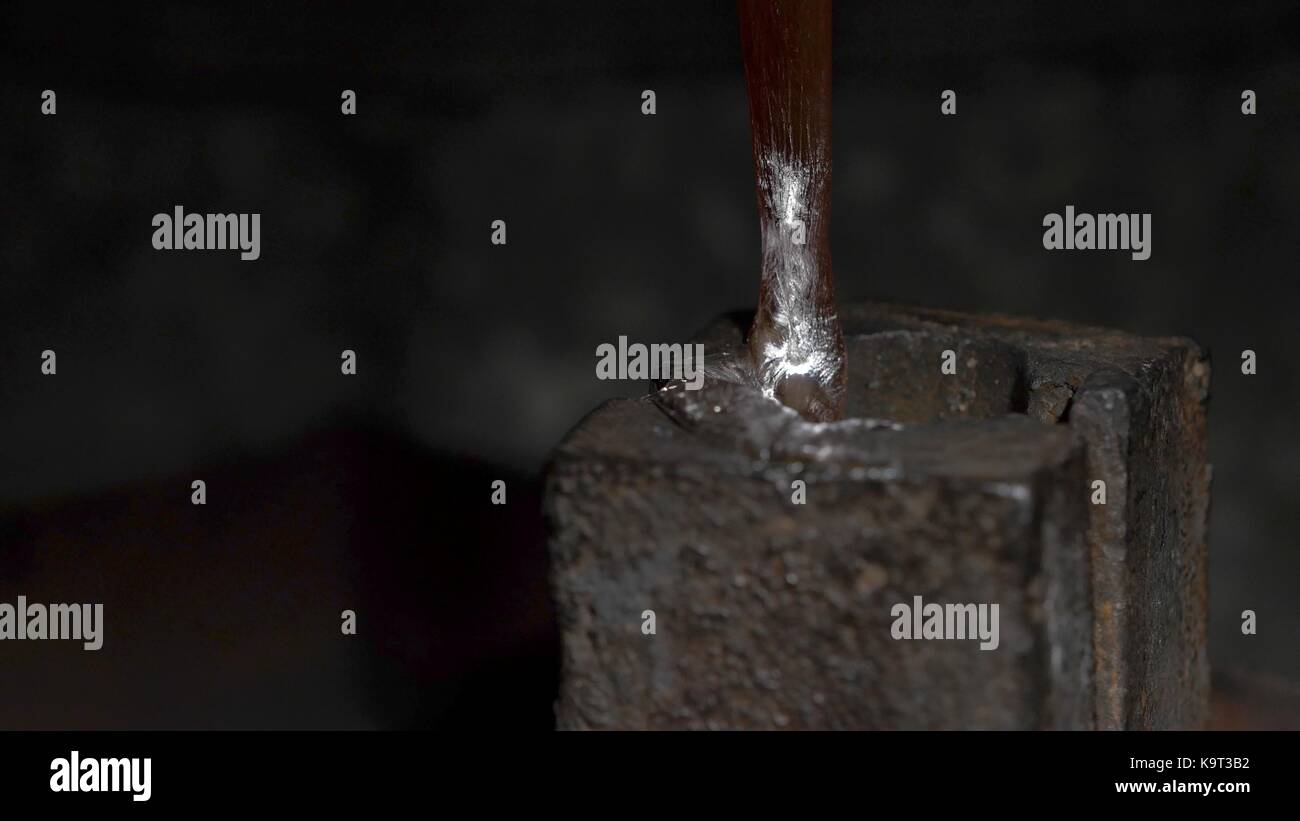 Pouring molten lead alloy into a mold. Workshop. Manufactory, manual ...