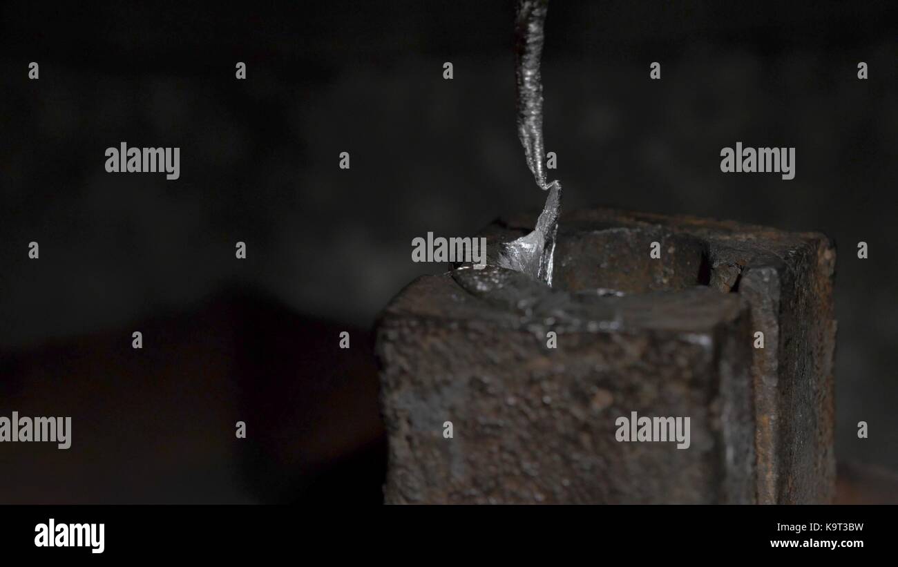 Pouring molten lead alloy into a mold. Workshop. Manufactory, manual ...