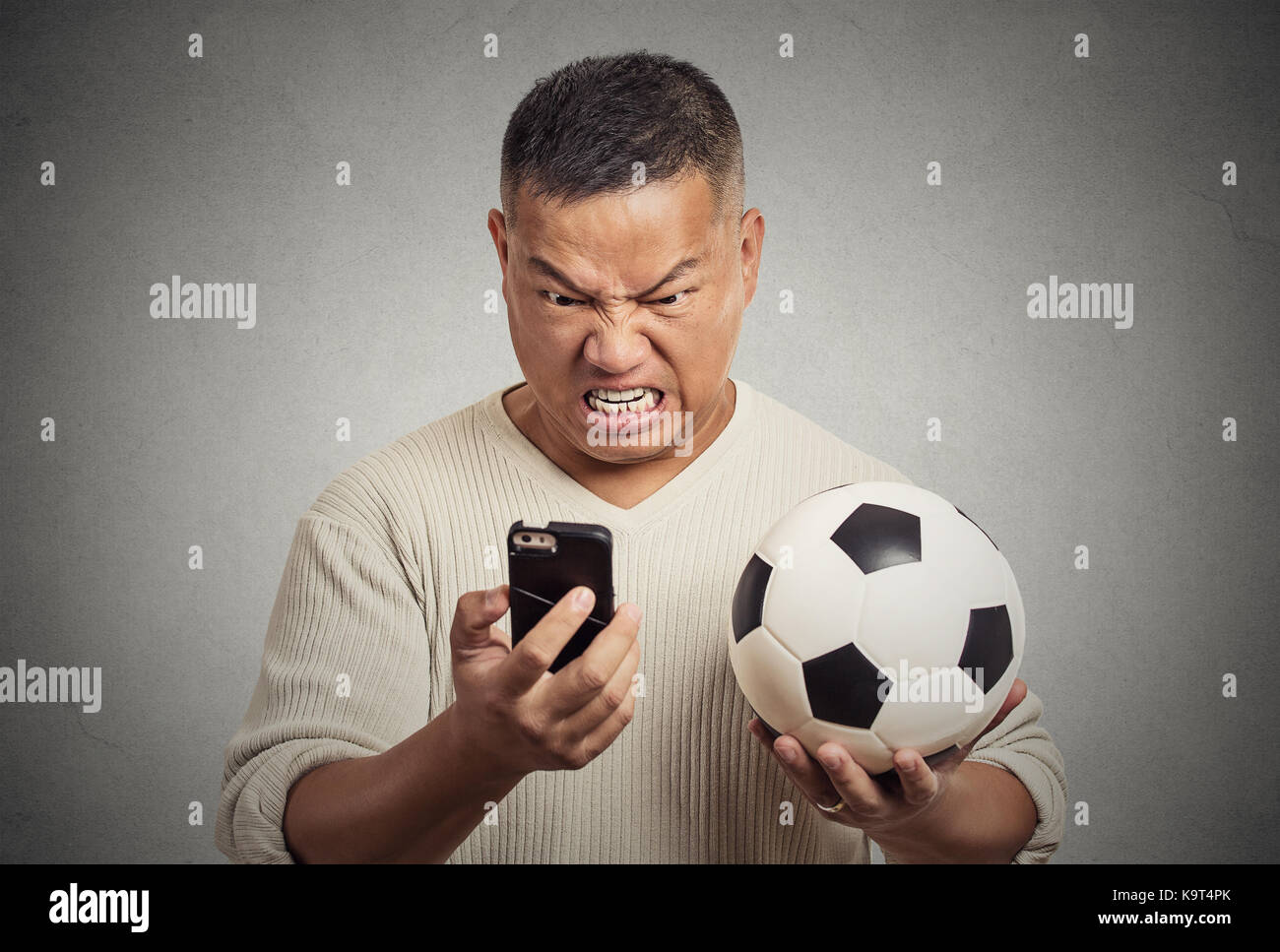 Portrait angry frustrated man looking on cell smart phone watching game ...