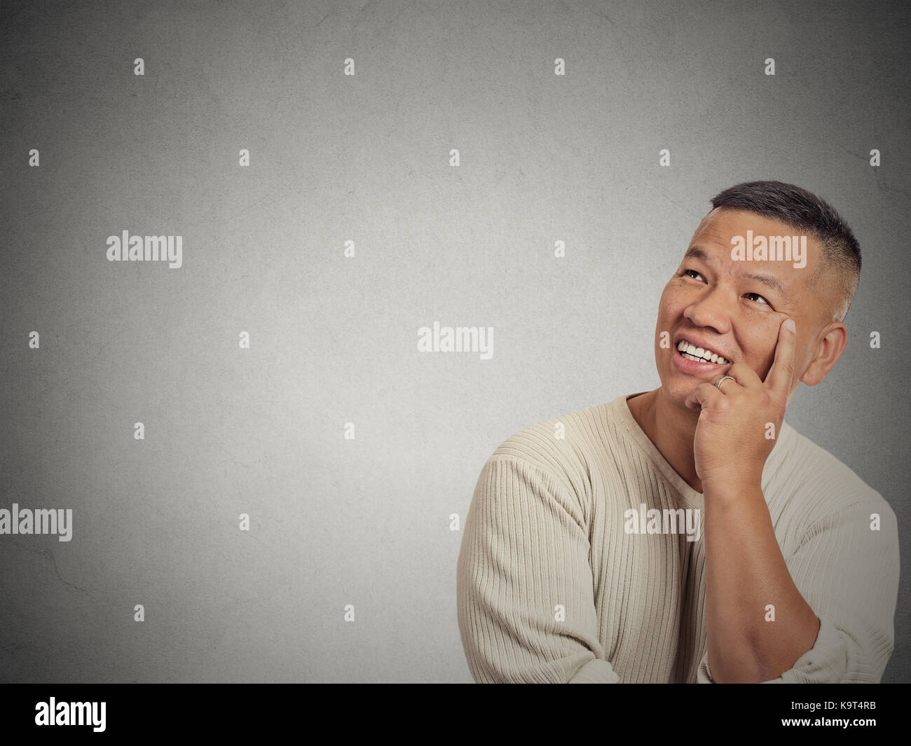 Portrait happy handsome man thinking looking up isolated grey wall ...
