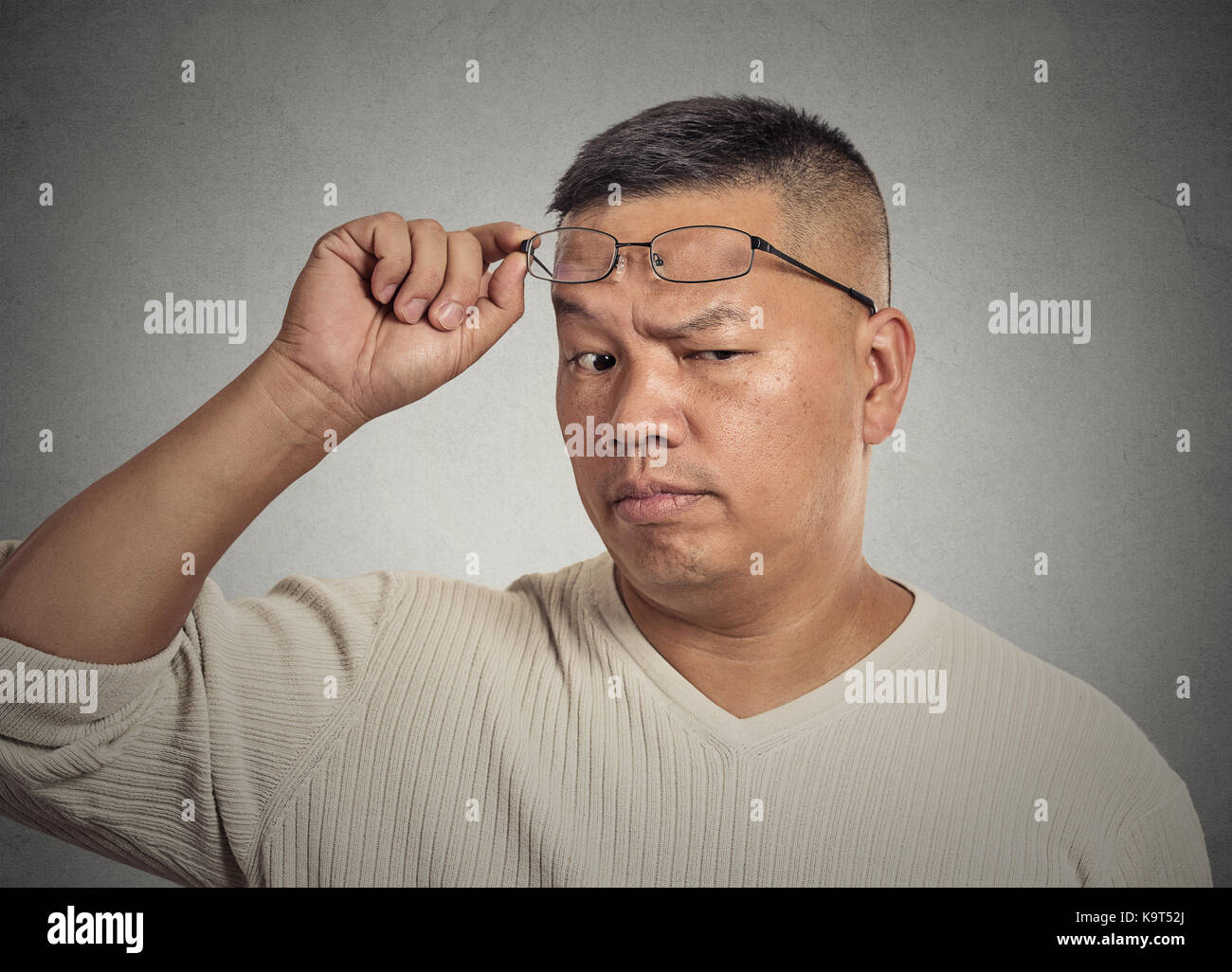 Headshot serious middle aged man with glasses skeptically looking at ...