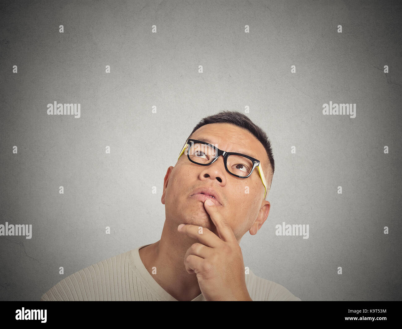 Portrait handsome man thinking looking up isolated on grey wall ...