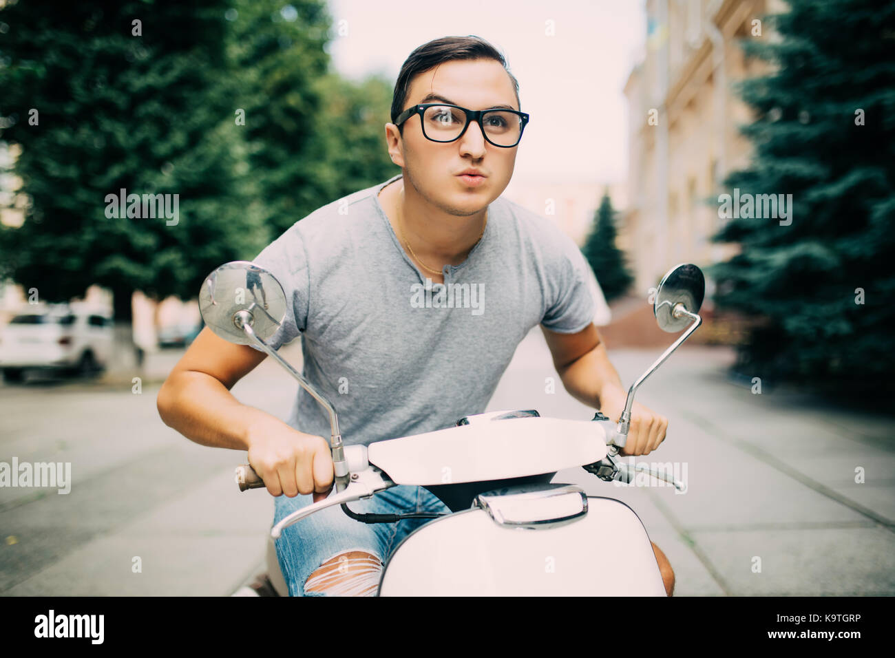 Young man riding scooter in the street Stock Photo - Alamy