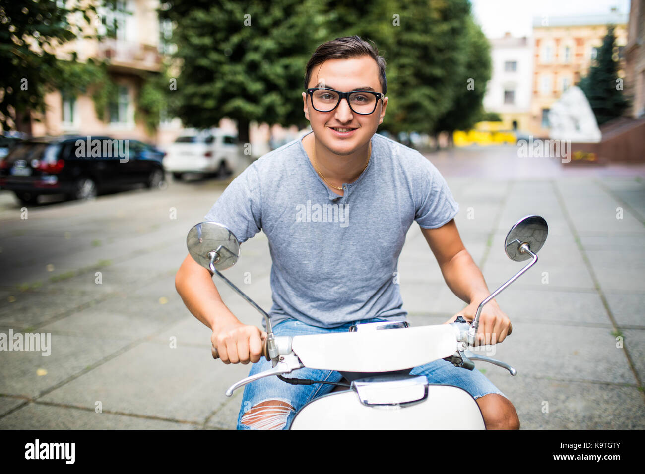 Young man riding scooter in the street Stock Photo - Alamy