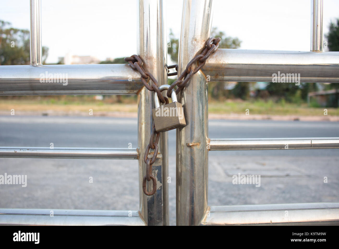 Gold Padlock with chain used on a chainlink fence. Selective focus is ...