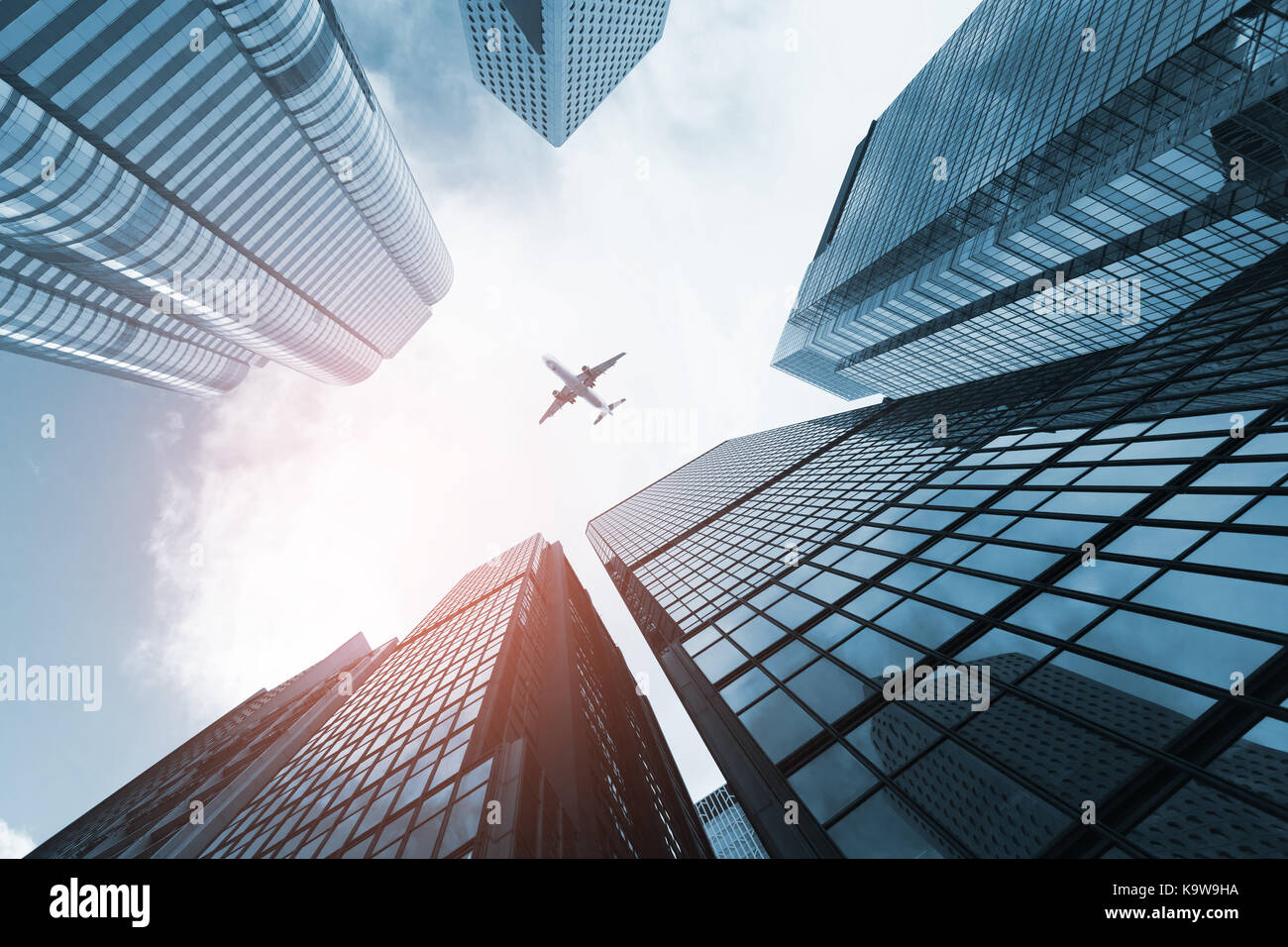 Urban skyline with passenger plane flying over business skyscrapers ...