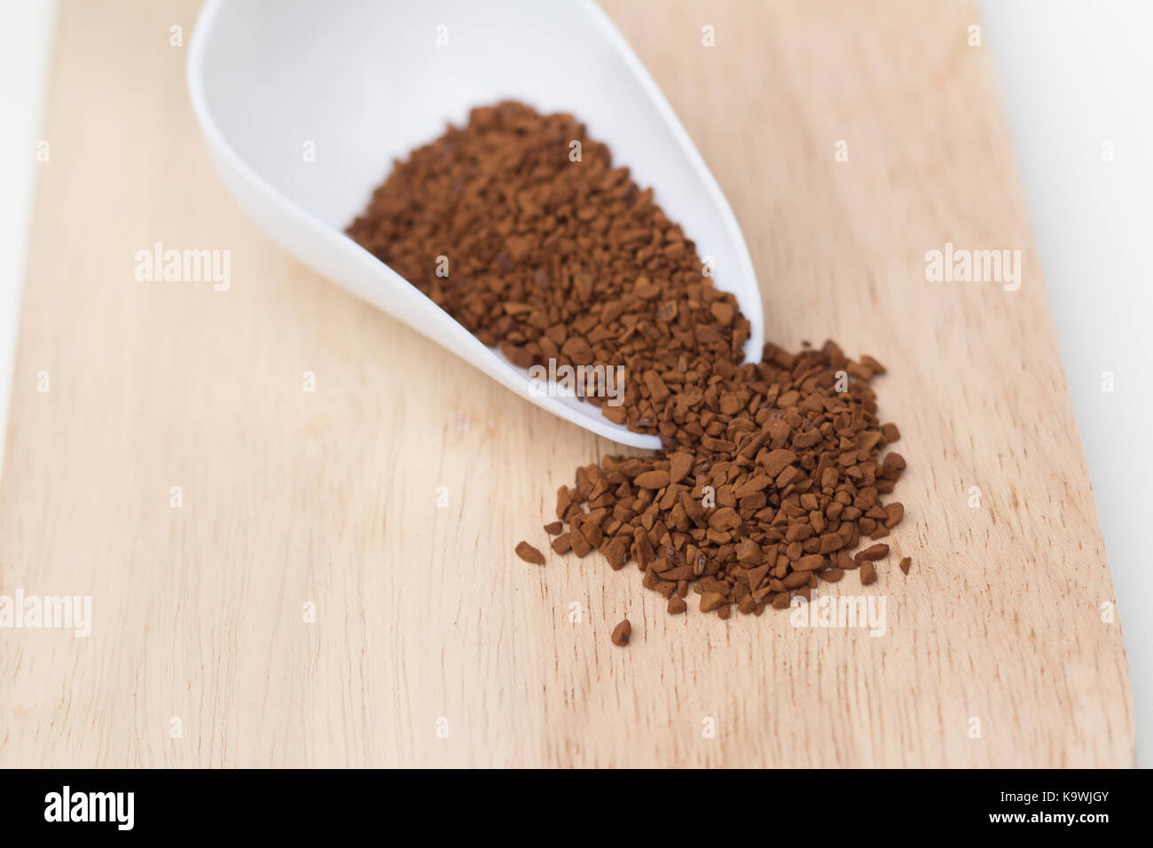 Instant coffee powder on wood plate and isolated on white background ...