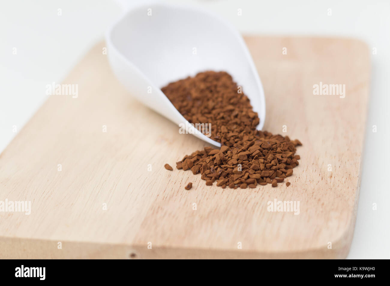 Instant coffee powder on wood plate and isolated on white background ...