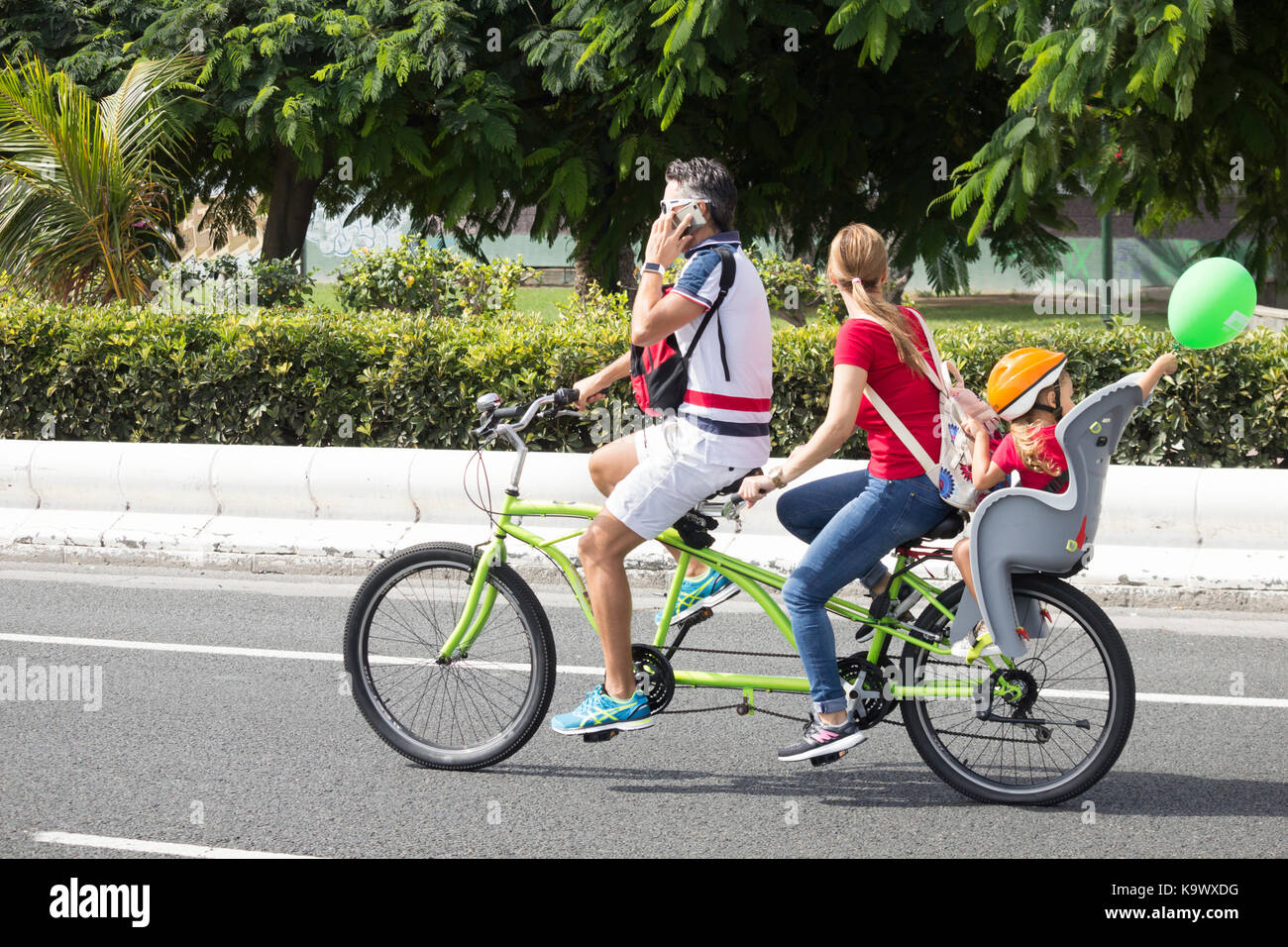 Man using moble phone while riding Tandem bicycle Stock Photo - Alamy