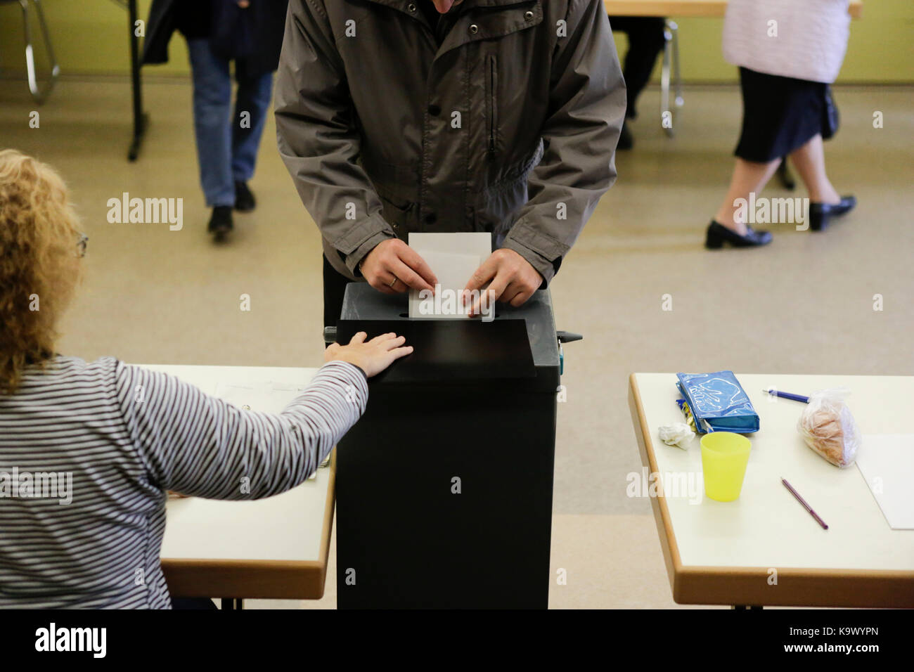 A voter puts his ballot papers into the polling box. Around 61.5 ...